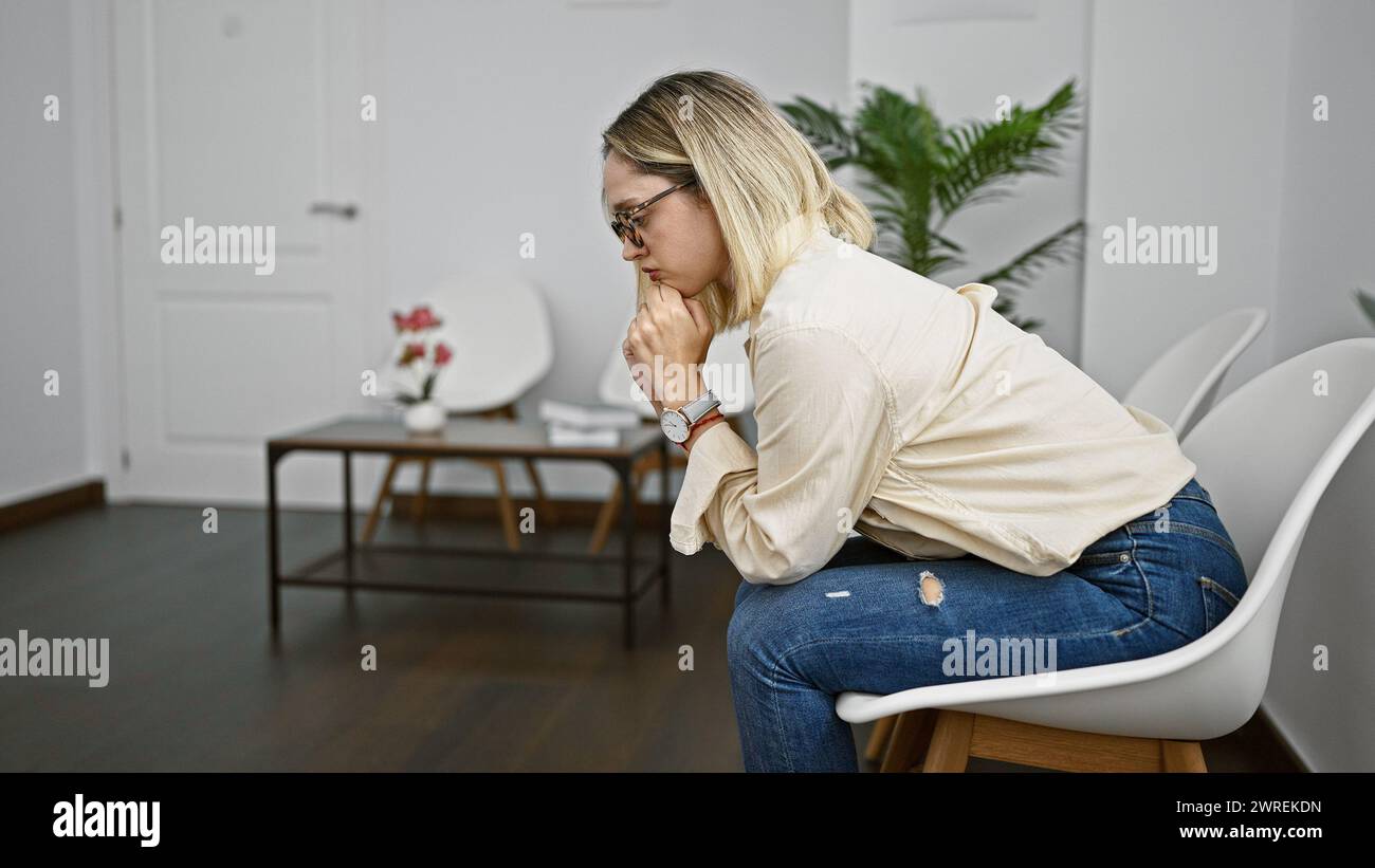 Young blonde woman business worker with nervous face sitting on chair ...
