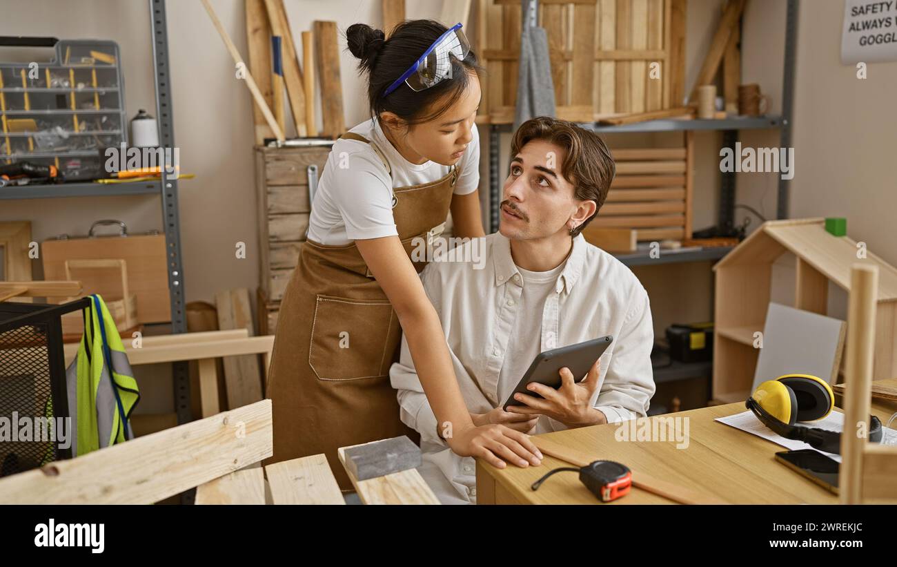 Man and girl in aprons collaborate in woodworking workshop with digital ...