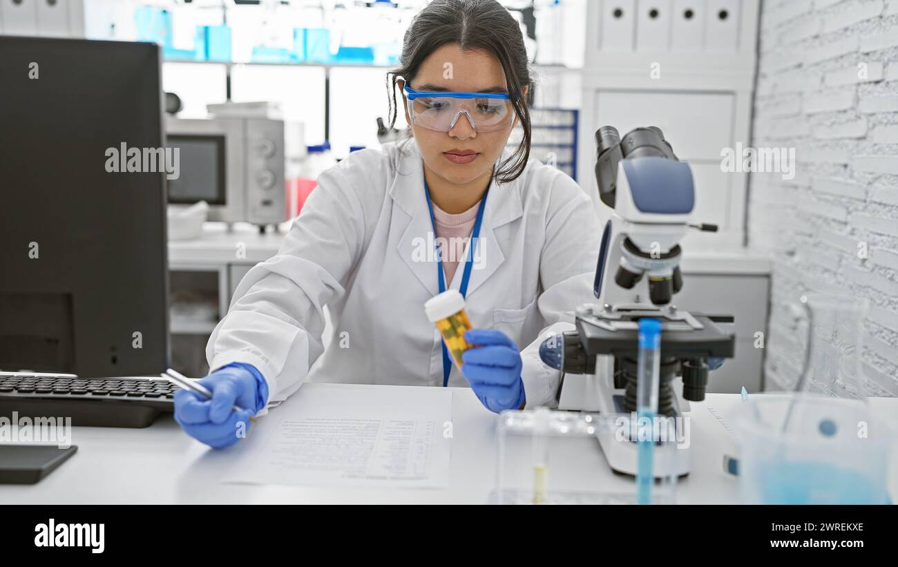 A focused hispanic woman scientist examines a sample in a lab setting ...
