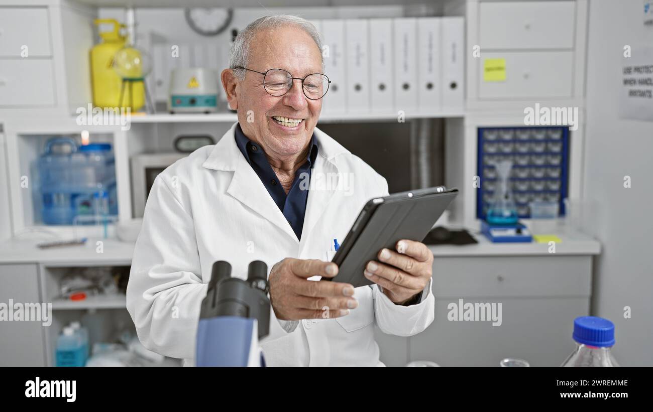 Senior man scientist smiling confident using touchpad at laboratory Stock Photo - Alamy