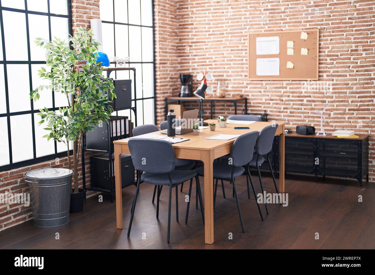 Modern office interior with wooden furniture, exposed brick wall, and ...