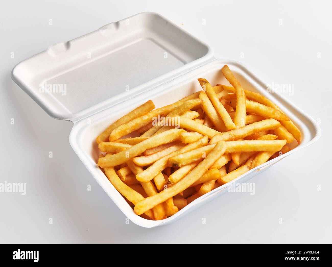 A styrofoam container filled with golden french fries isolated on a ...