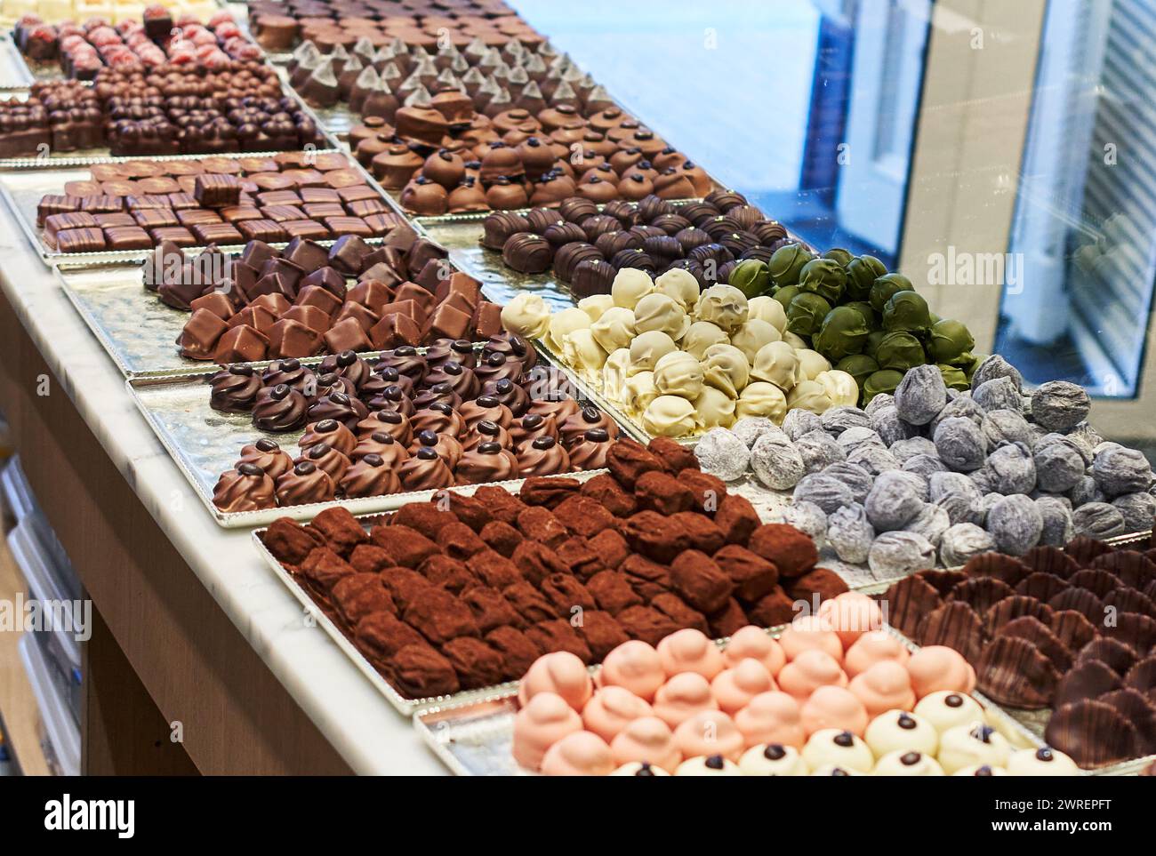 Assorted chocolates displayed in a confectionery store, tempting with ...