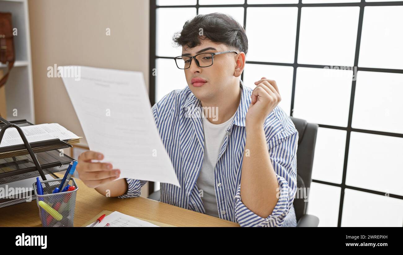 Young man reviews document thoughtfully in a bright, modern office ...