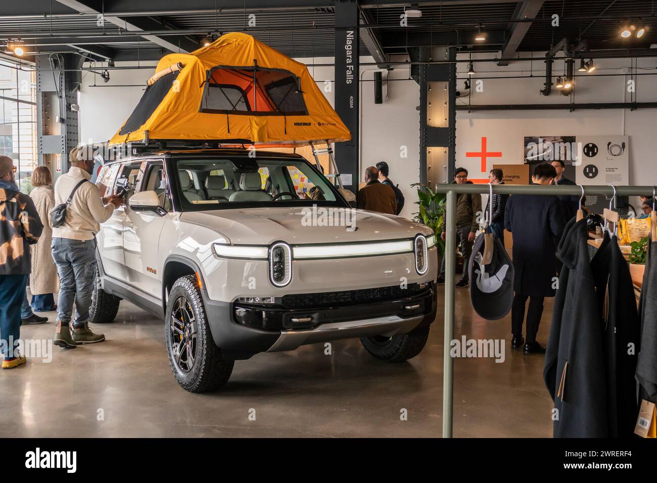 Automobile enthusiasts admire the electric Rivian R1S at an ...
