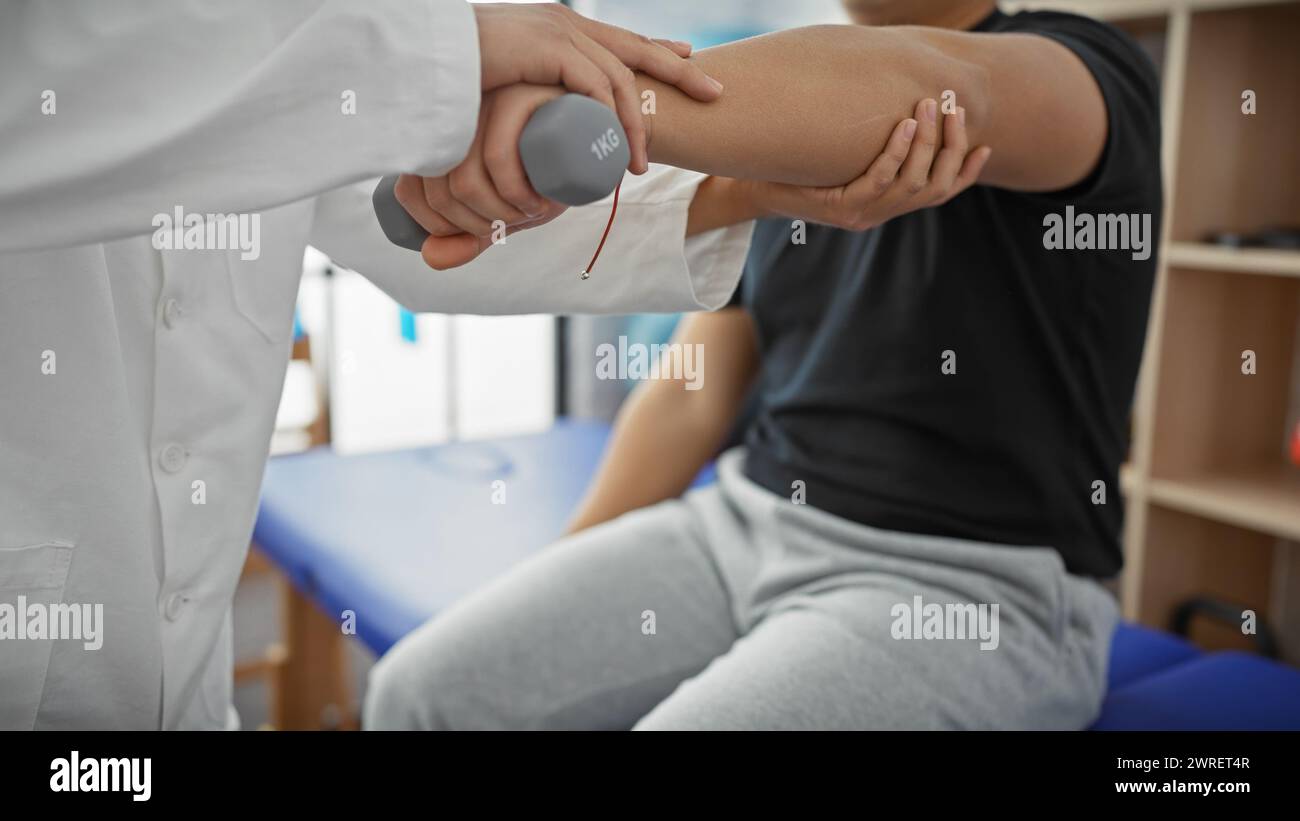 Physiotherapist guiding a male patient through arm rehabilitation using ...