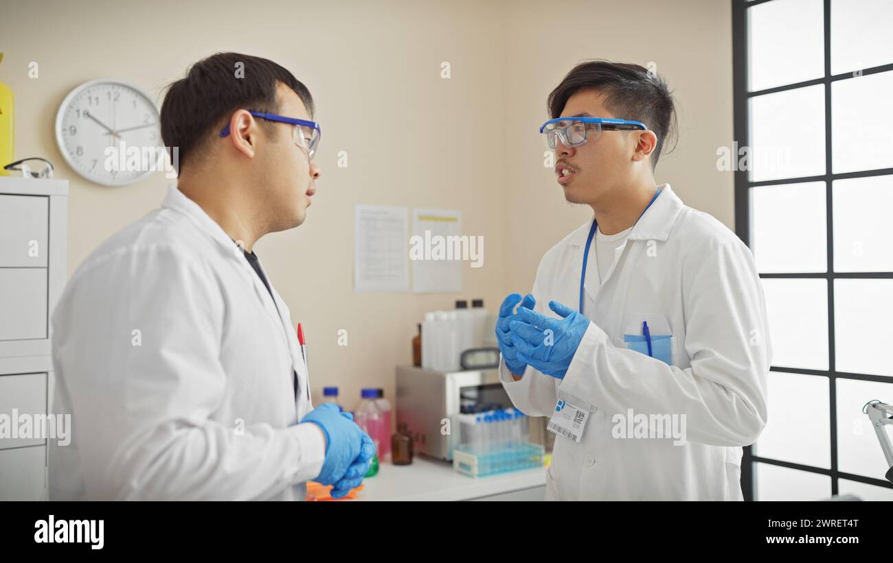 Two male scientists in discussion inside a brightly lit laboratory ... Two male scientists in discussion inside a brightly lit laboratory ...