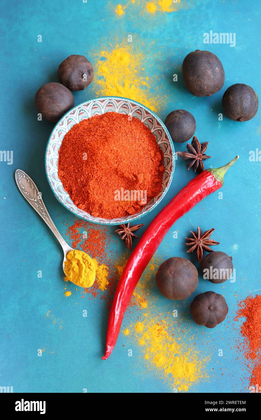 Still life with different spices on blue background with copy space. Vivid colors of food ...