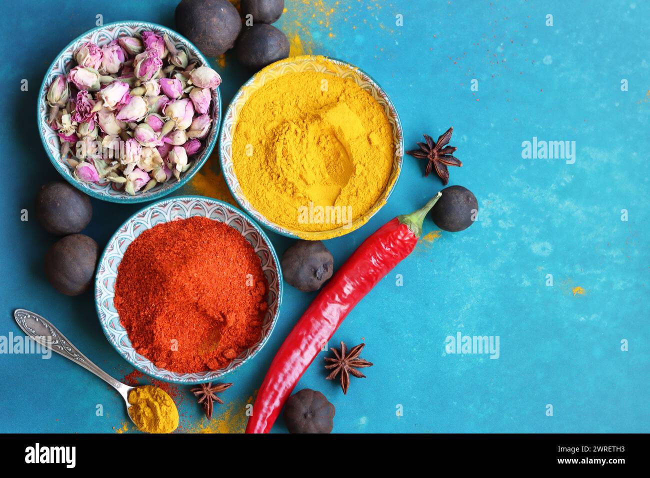 Still life with different spices on blue background with copy space. Vivid colors of food ...