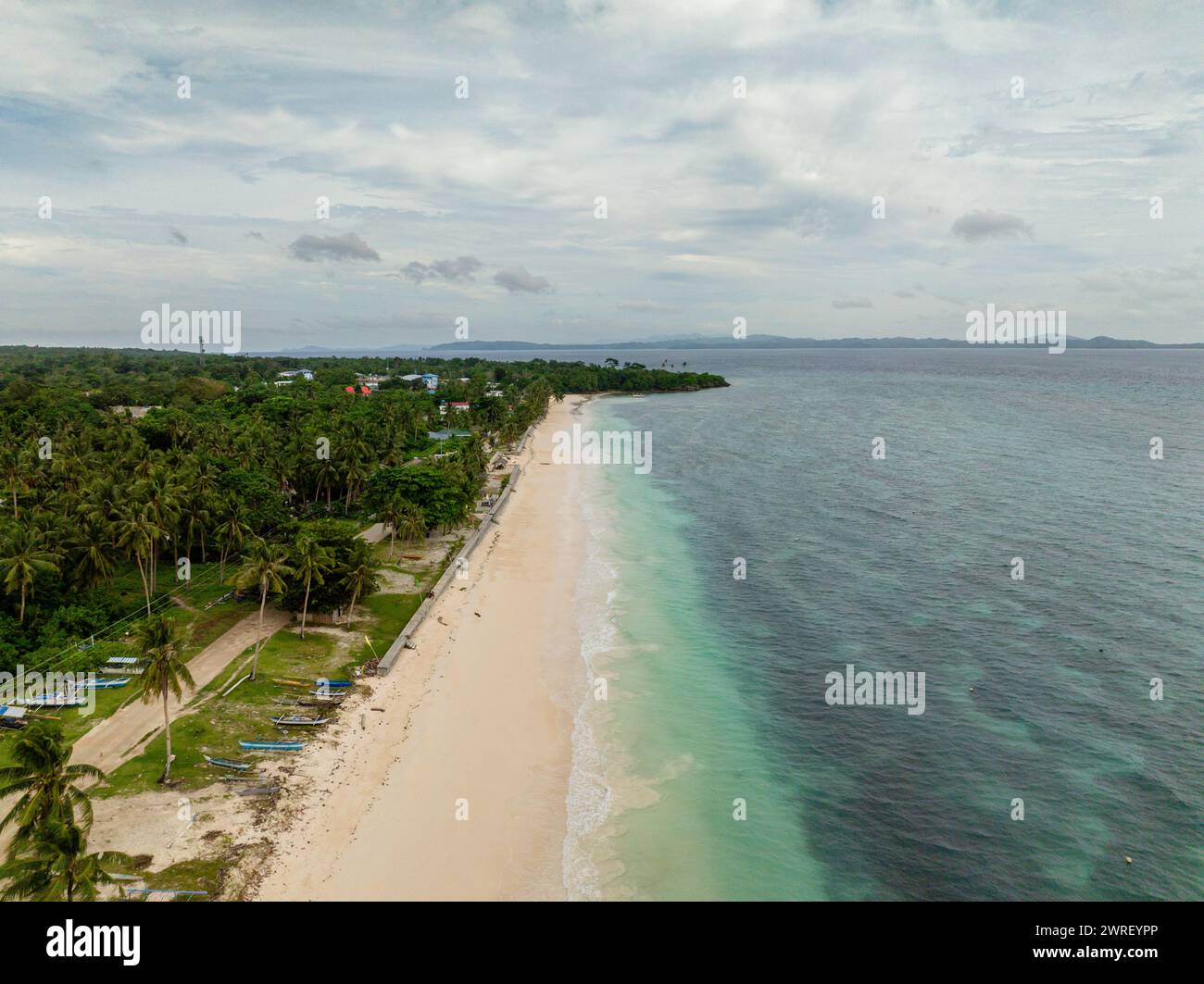 Poblacion San Jose and white sandy beach with ocean waves in Carabao ...