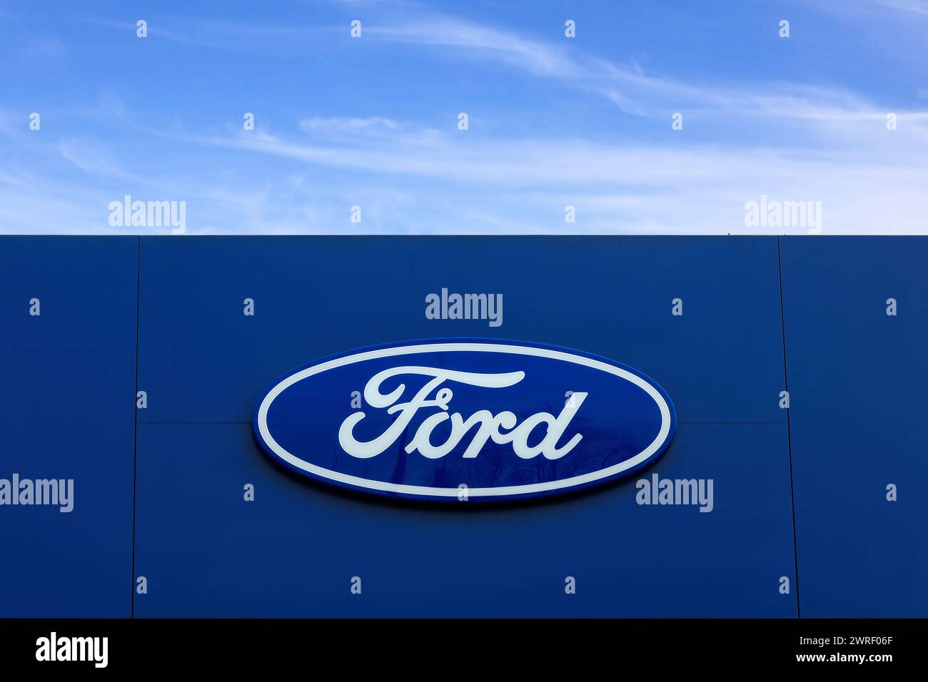 Ford Motor Company logo at dealership against blue sky. The company was ...