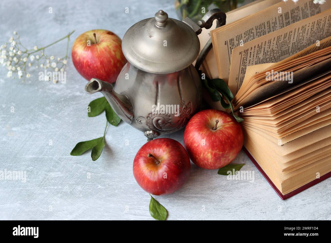 Retro styled still life with an open book on a desk. Close up photo of ...
