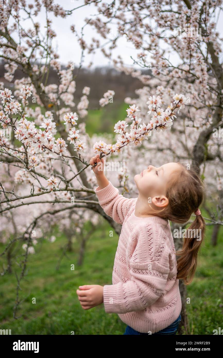 Lovely little girl in a blooming pink and white garden Petrin in Prague ...