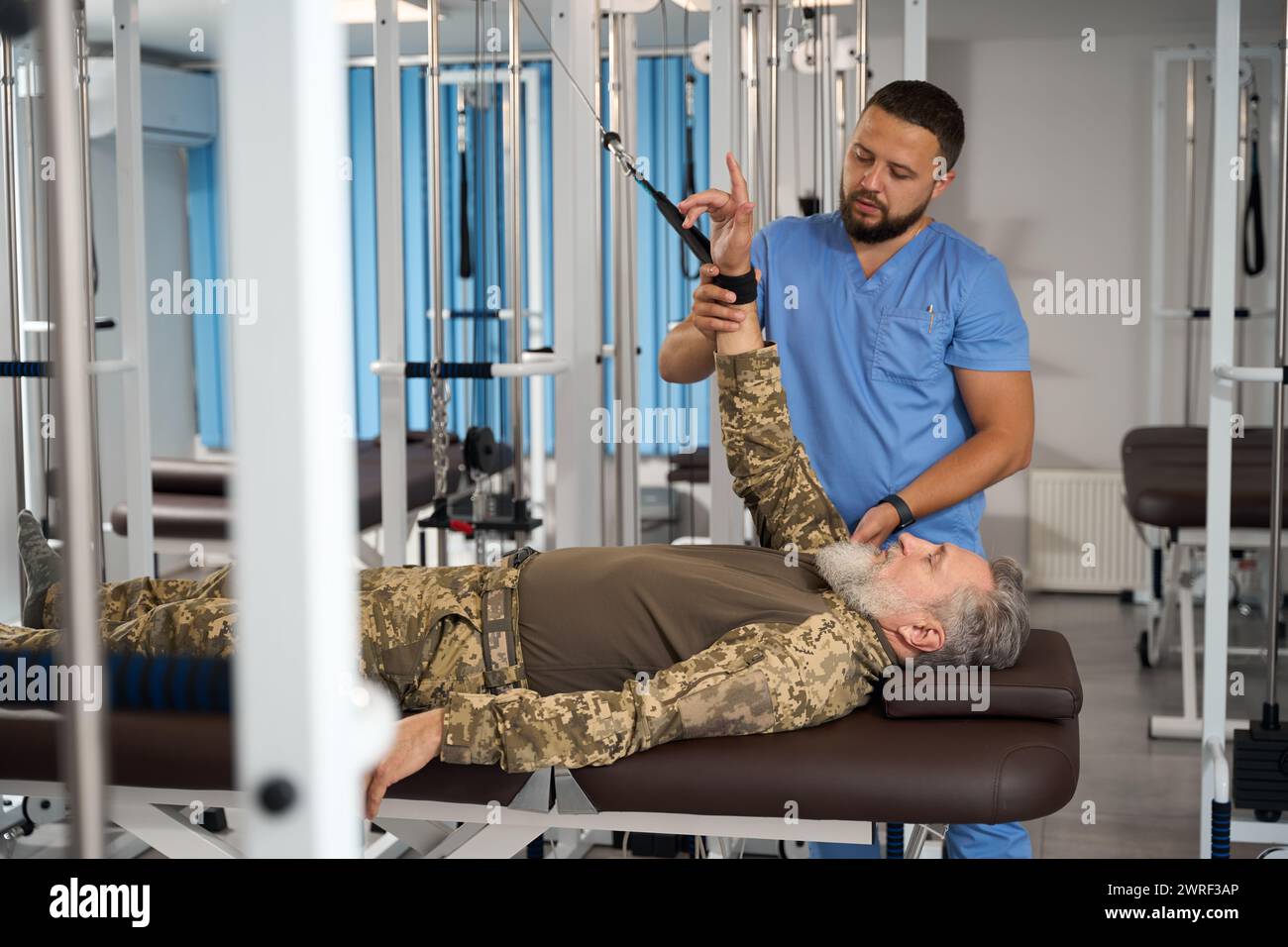 Rehabilitation therapist helps a patient perform exercises Stock Photo ...