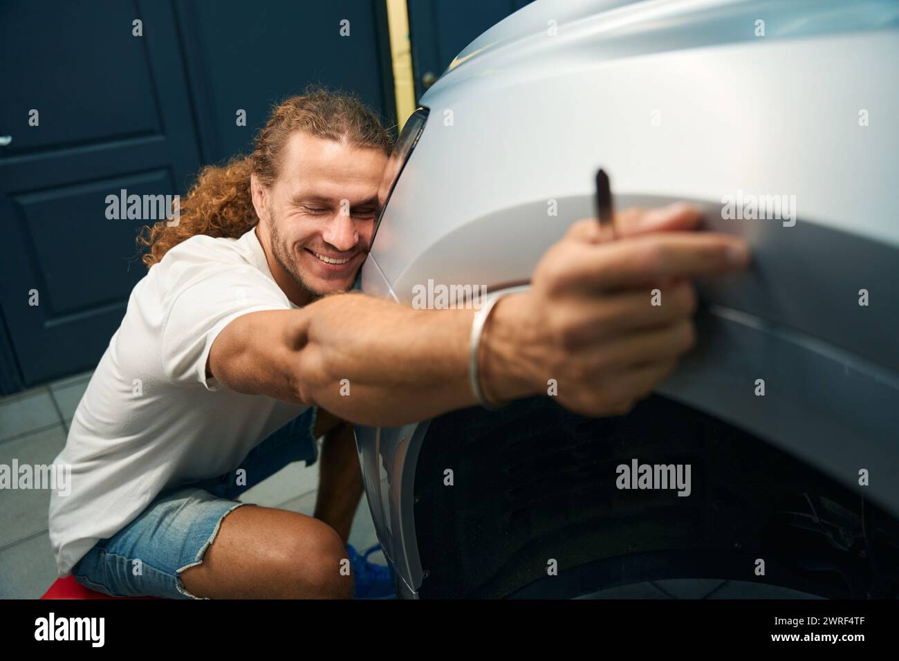 Happy guy is hugging his favorite car Stock Photo - Alamy