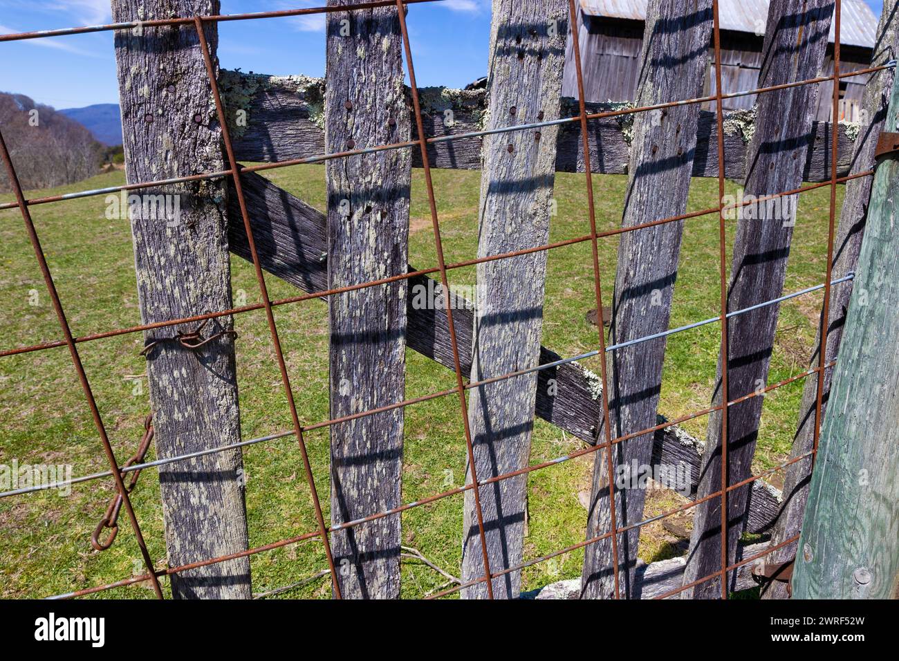 landscape view and section of an old barn can be seen through the wire ...