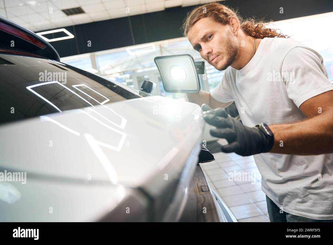 Auto mechanic conducts a check inspection of the car body Stock Photo ...