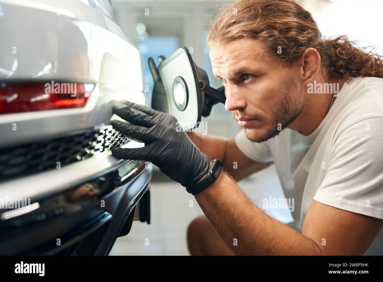 Guy in car repair shop is conducting check inspection of car body Stock ...