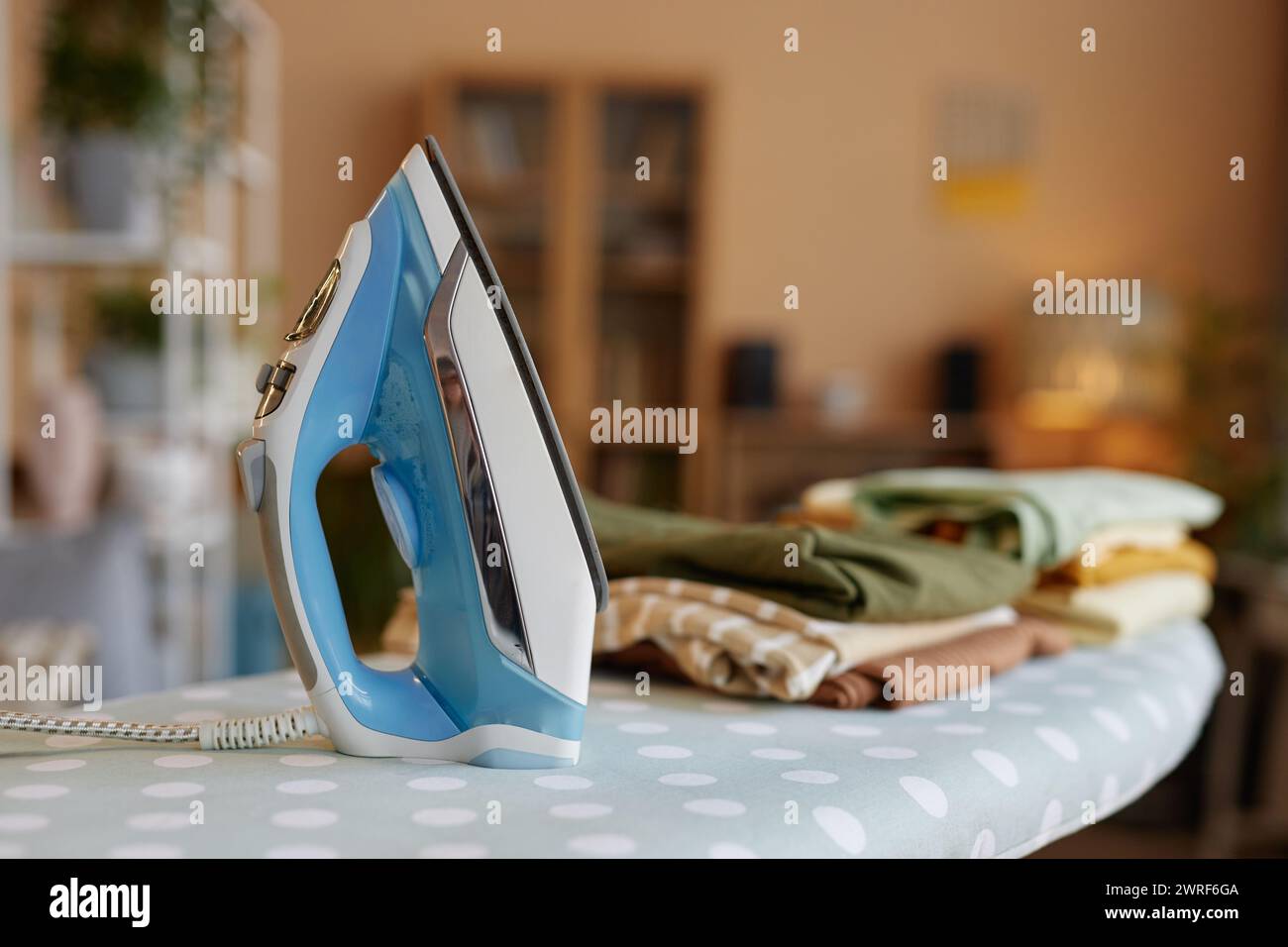 Close up background image of light blue iron on ironing board with ...