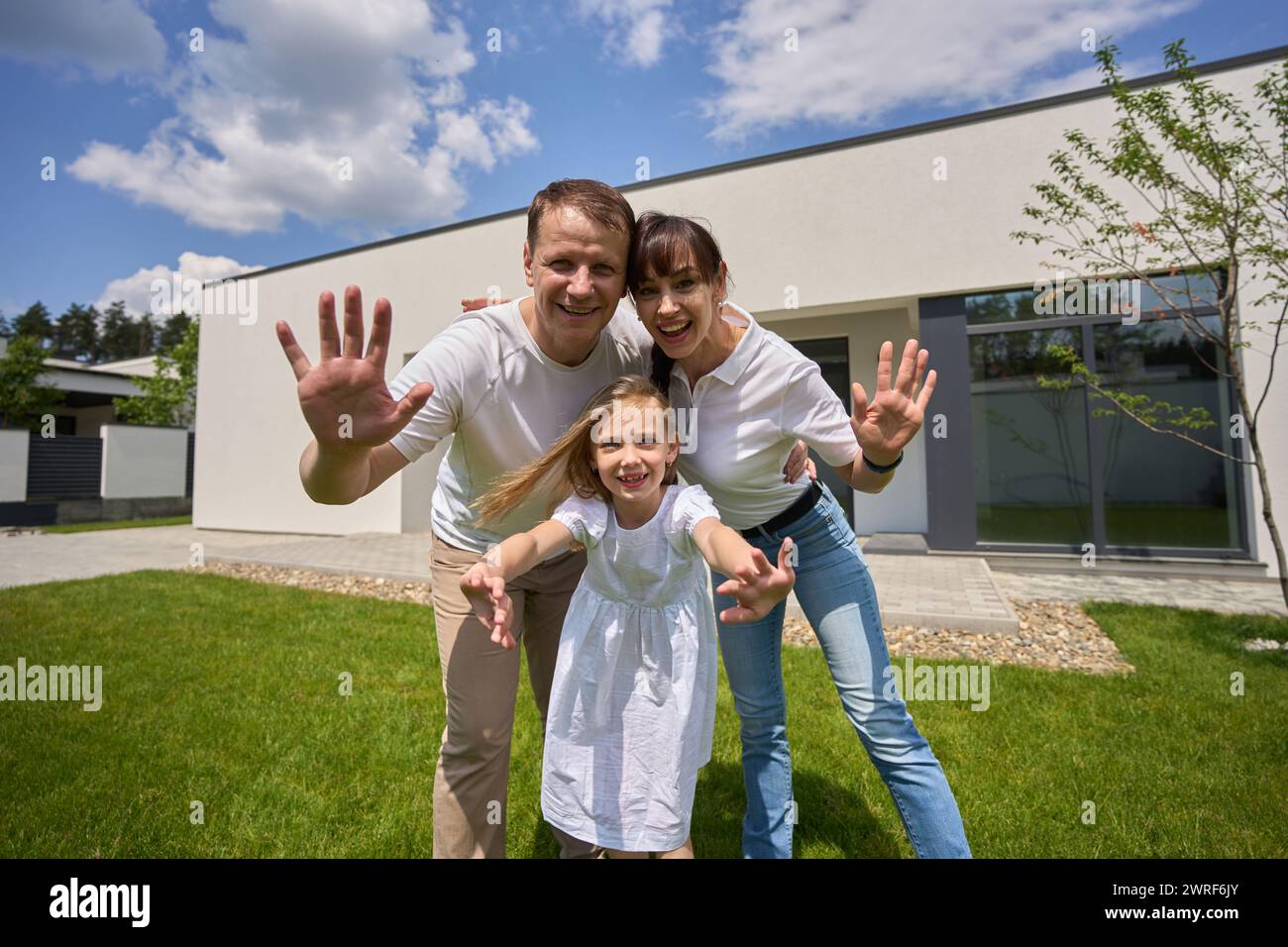 Pleased family hugging waving hi-res stock photography and images - Alamy