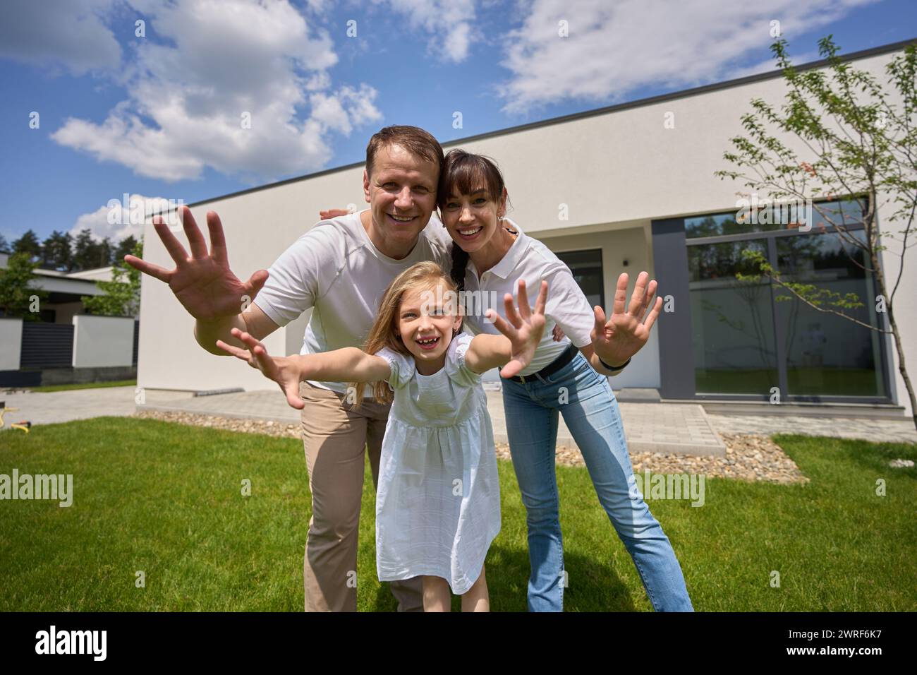 Pleased family hugging waving hi-res stock photography and images - Alamy