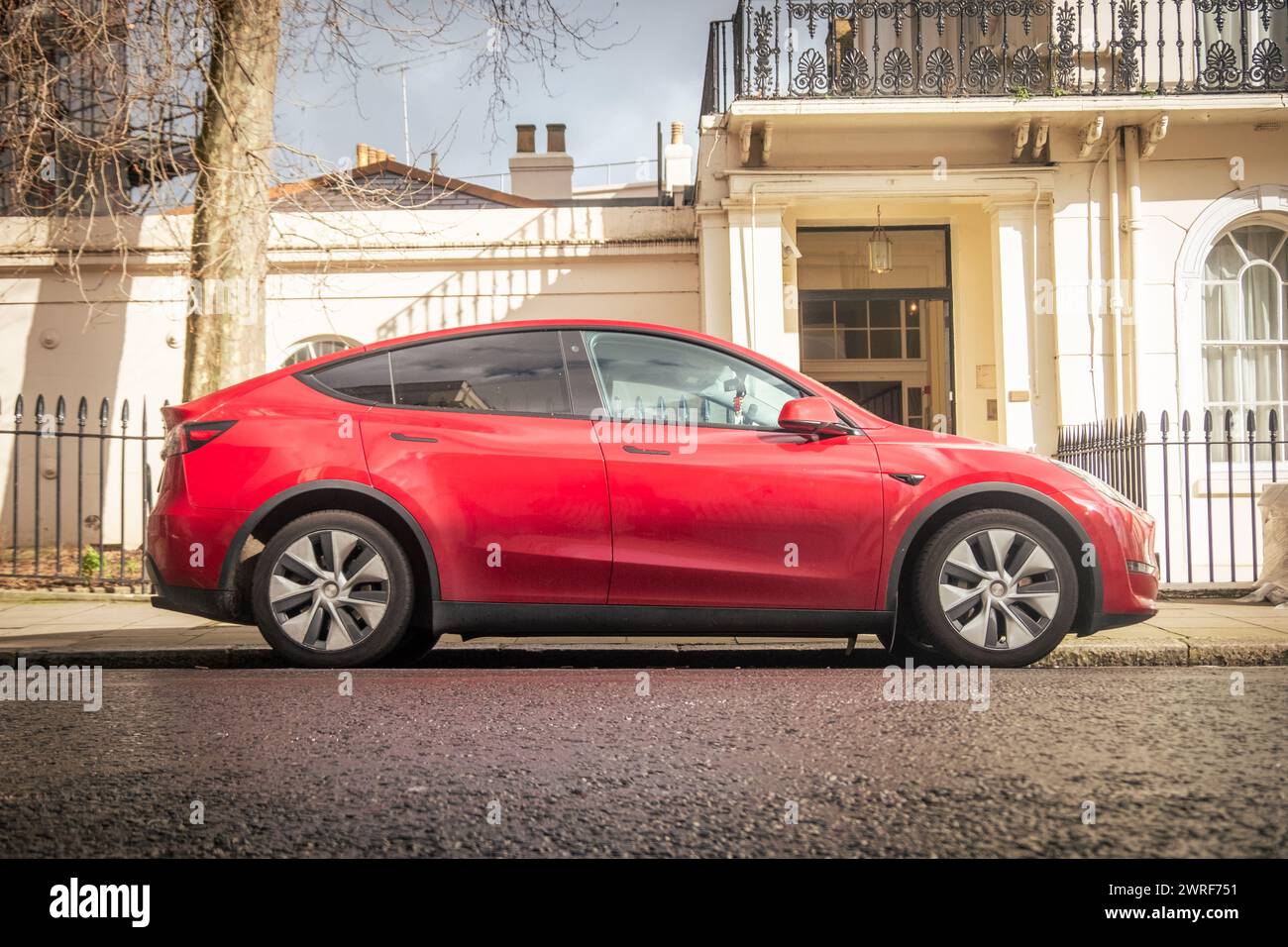 LONDON- FEBRUARY 19, 2024: Tesla Model 3 parked on upmarket residential ...
