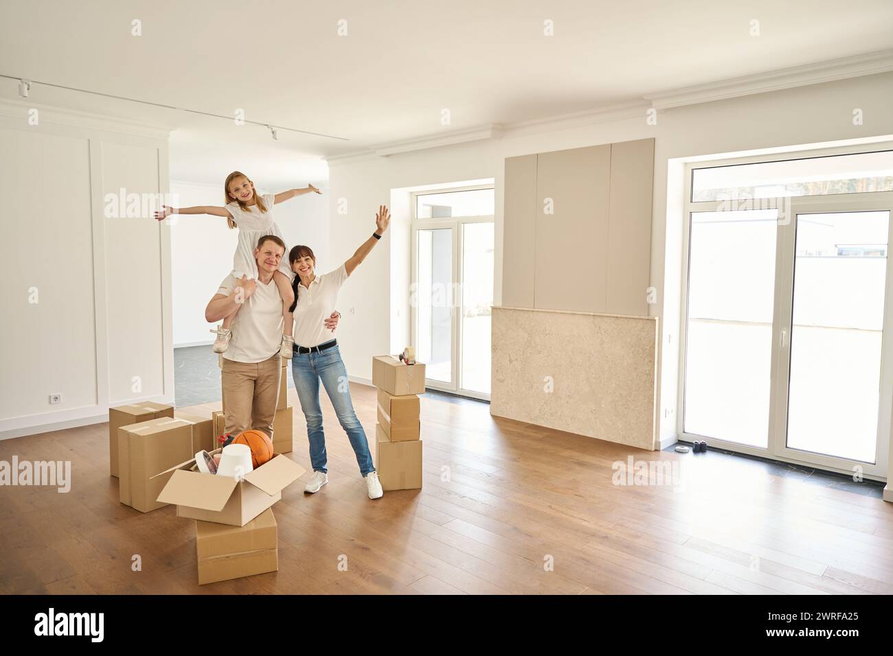 Happy parents with child in middle of spacious empty room Stock Photo ...