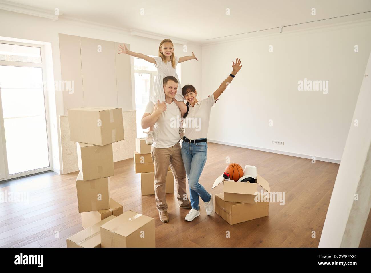 Happy family in the middle of a spacious empty room Stock Photo - Alamy