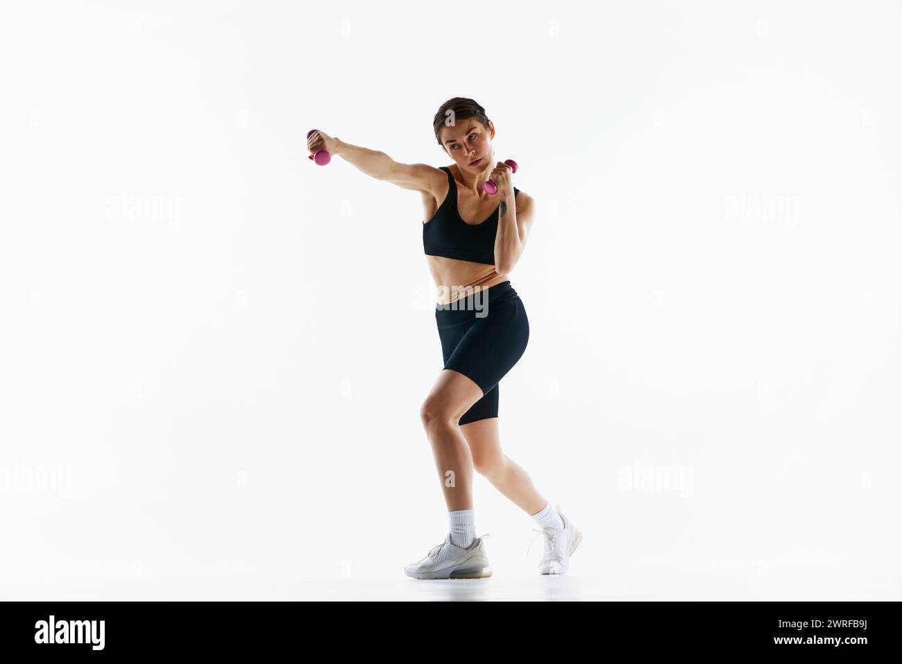 Young woman with slim sportive body training, doing jab exercises with ...