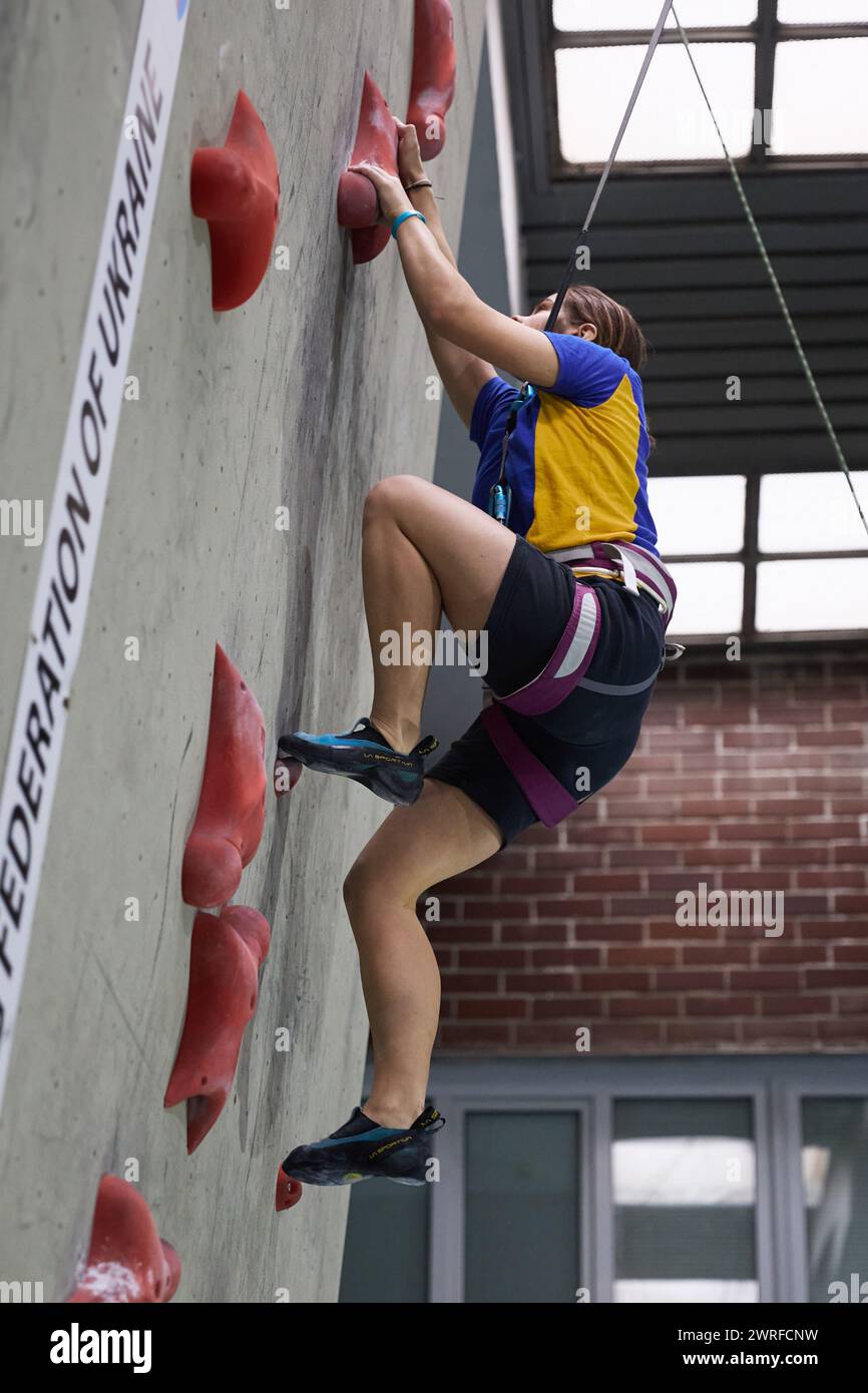 Young climber goes up the vertical wall fast at a speed climbing ...