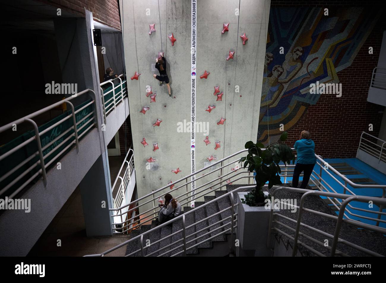 Athlete climbing the high vertical wall apparatus at a professional ...