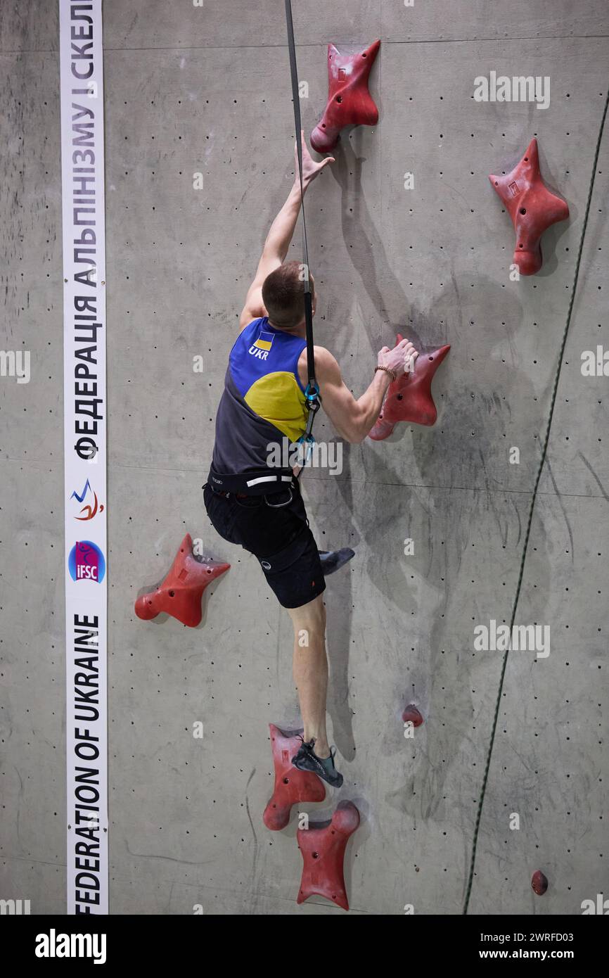 Strong young climber goes to the top of a vertical wall at a speed ...