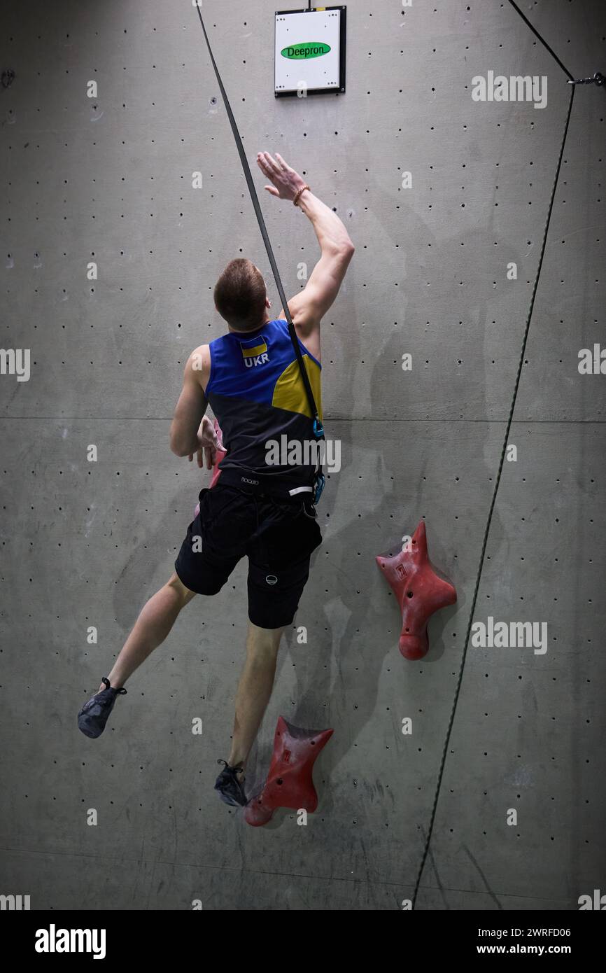 Male climber hits the button on top of the vertical wall at a speed ...
