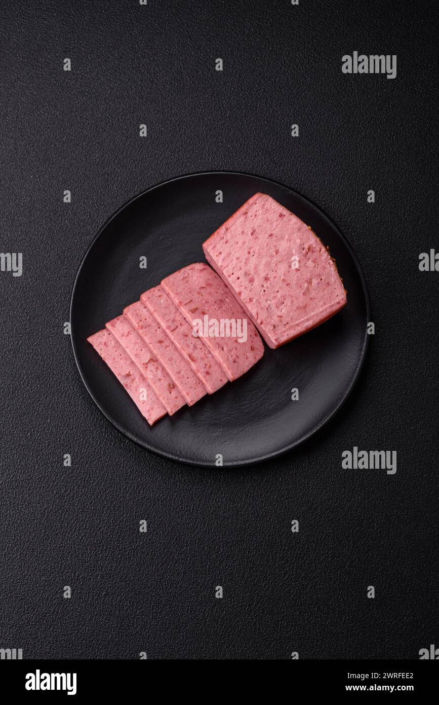 Delicious canned pink ham with salt, spices and herbs on a dark ...