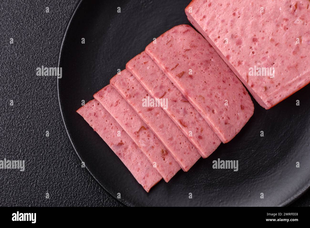 Delicious canned pink ham with salt, spices and herbs on a dark ...