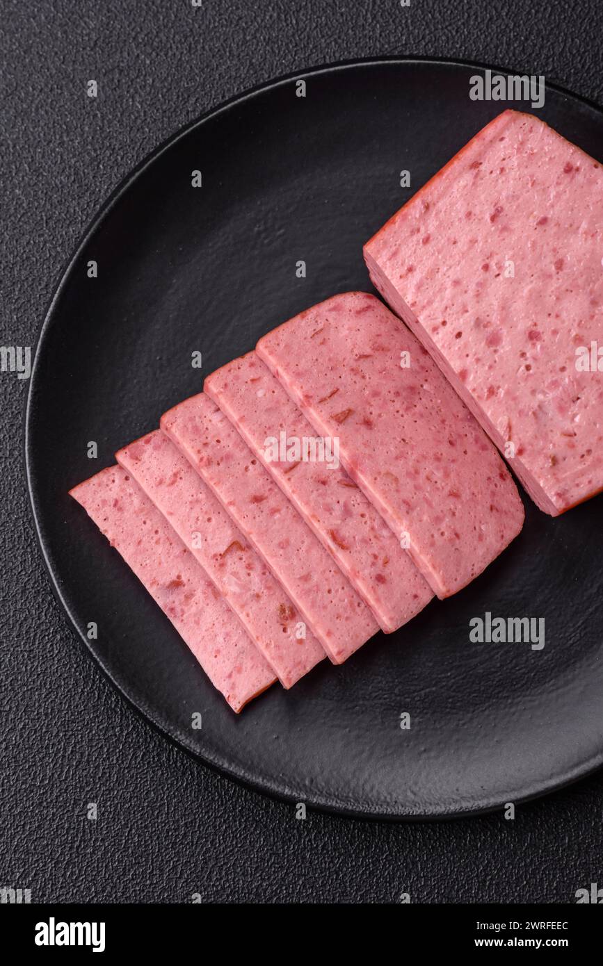 Delicious canned pink ham with salt, spices and herbs on a dark ...