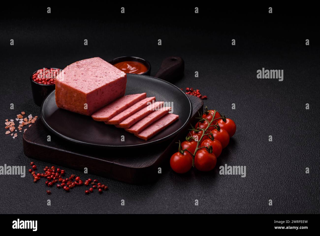 Delicious canned pink ham with salt, spices and herbs on a dark ...