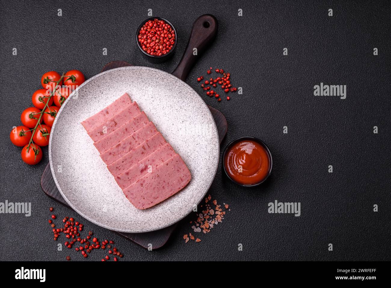 Delicious canned pink ham with salt, spices and herbs on a dark ...