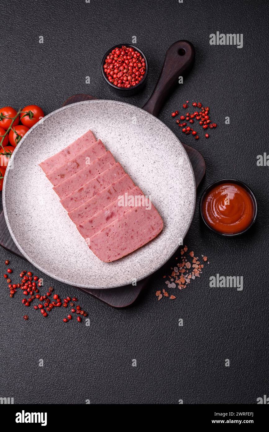 Delicious canned pink ham with salt, spices and herbs on a dark ...