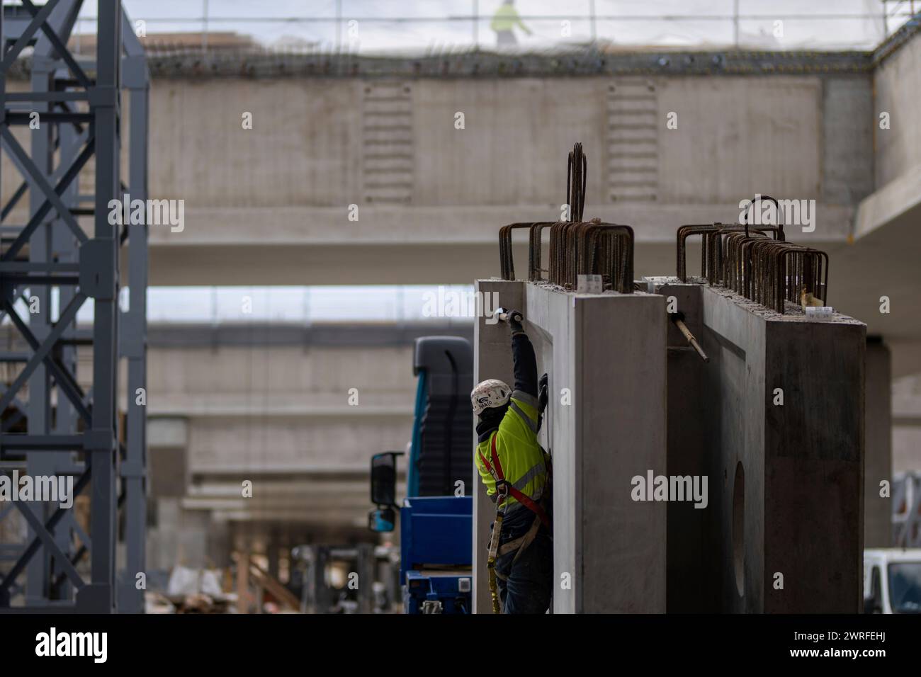 A worker works on the new phase of the central structure of the roof of ...
