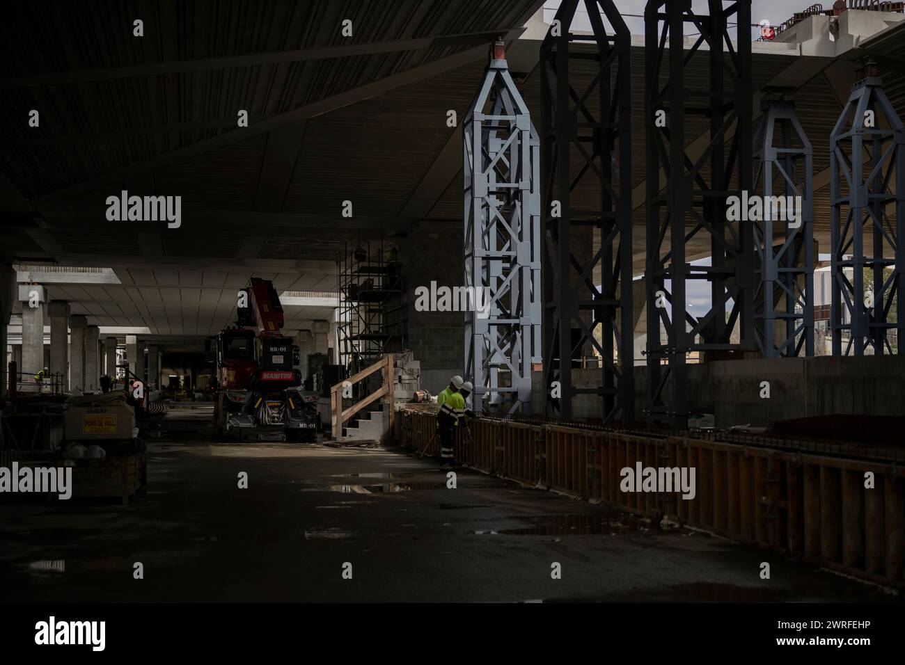 A worker works on the new phase of the central structure of the roof of ...