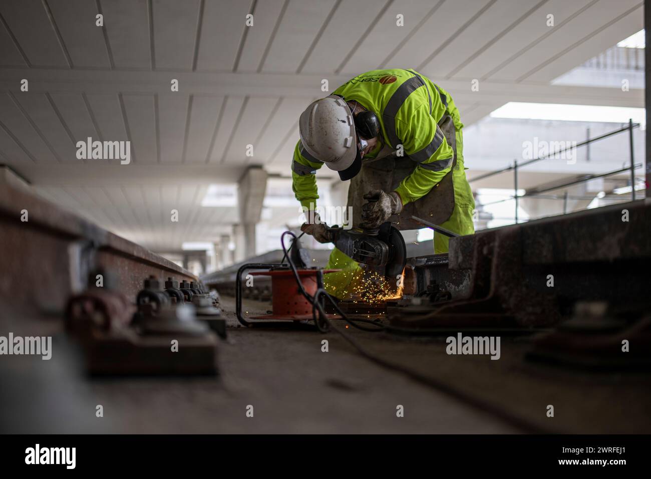 A worker works on the new phase of the central structure of the roof of ...