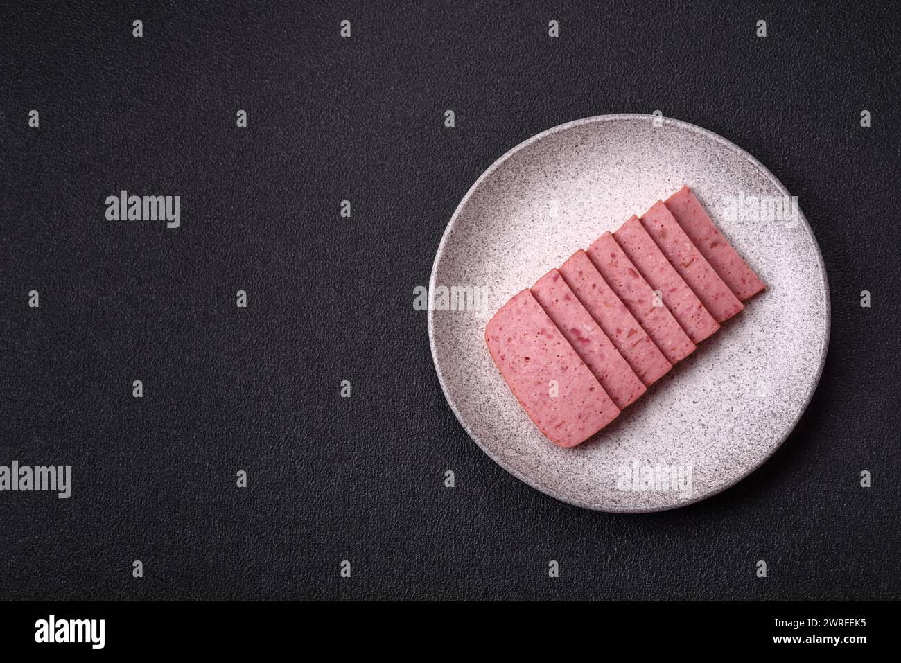 Delicious canned pink ham with salt, spices and herbs on a dark ...