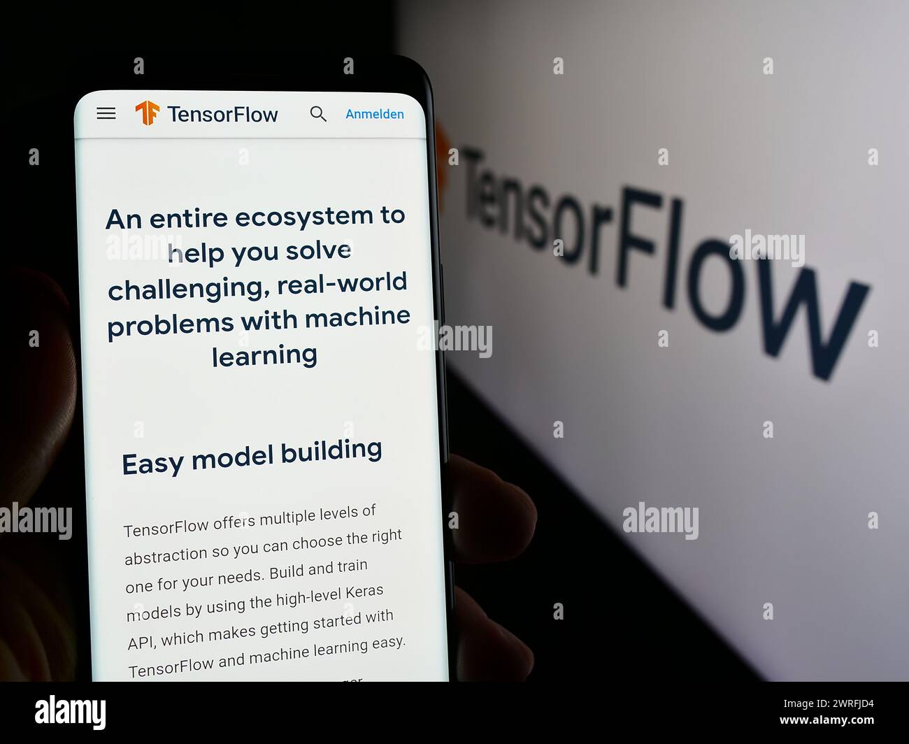Person holding mobile phone with web page of open-source software ...