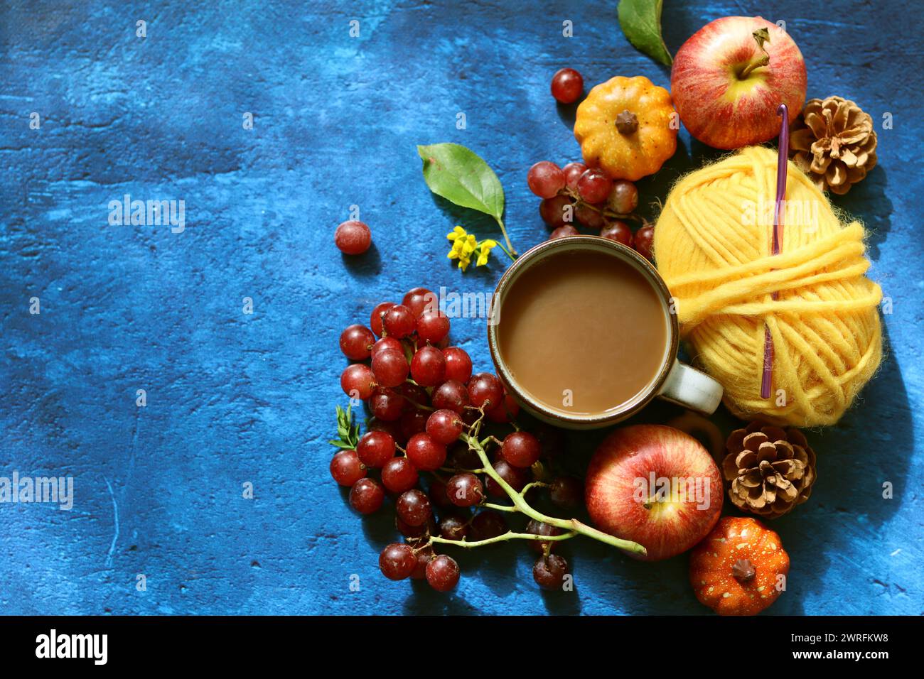 Cozy autumn still life with red apples and woolen yarn balls. Hobby and ...