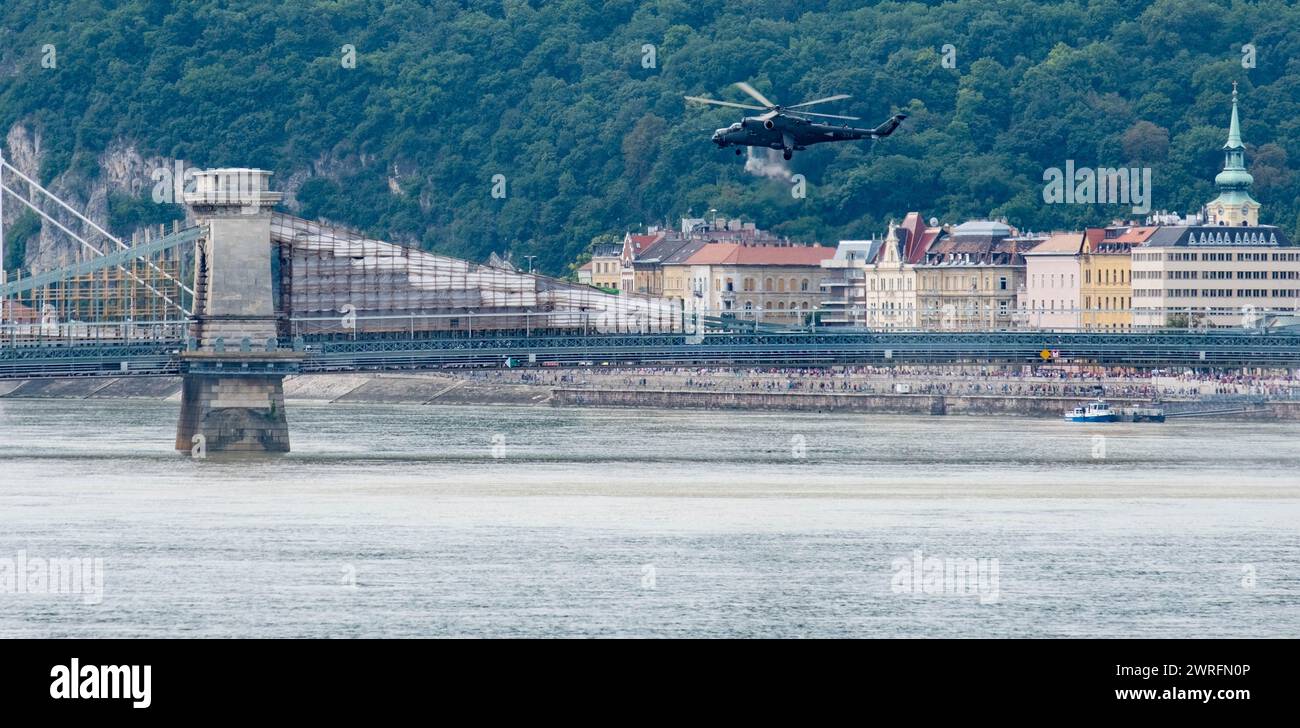 A military helicopter flying low over a crowded bridge near classical ...