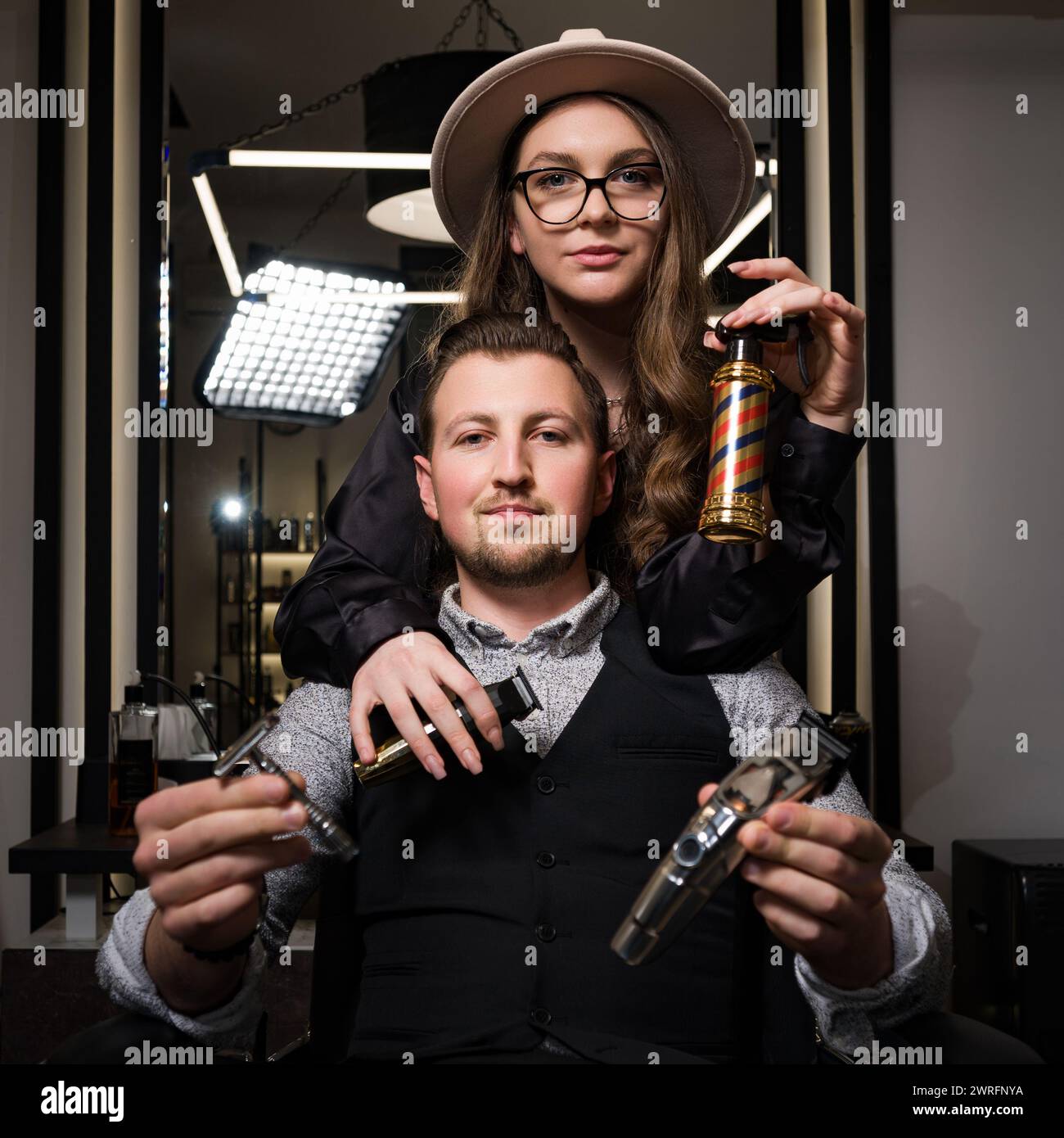 Barber man and girl are holding tools with barbershop attributes ...