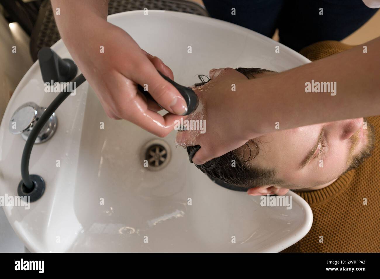Barber shampooing a client hi-res stock photography and images - Alamy