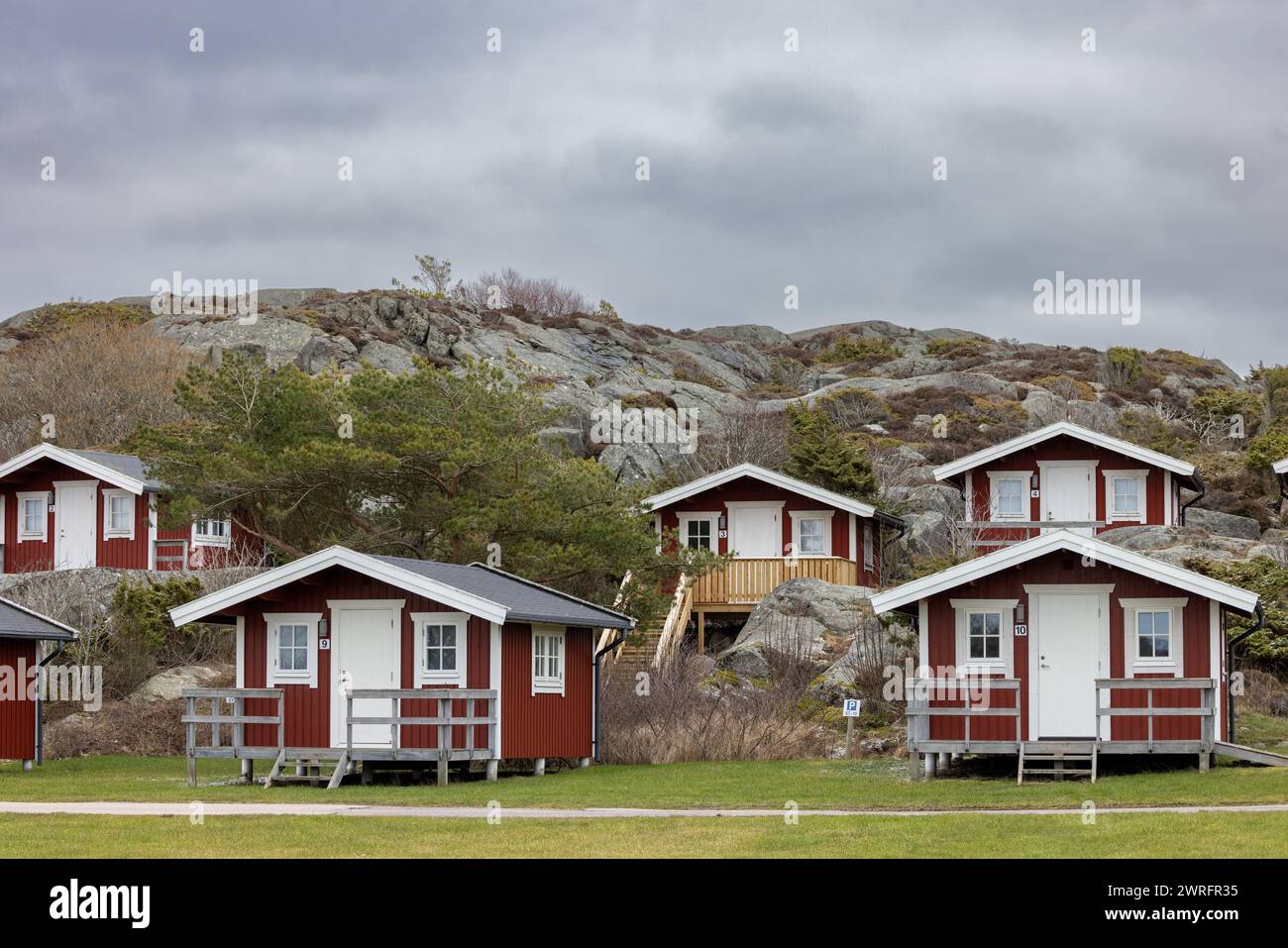 Red and white wooden summer vacation cabins on grey day with heavy ...