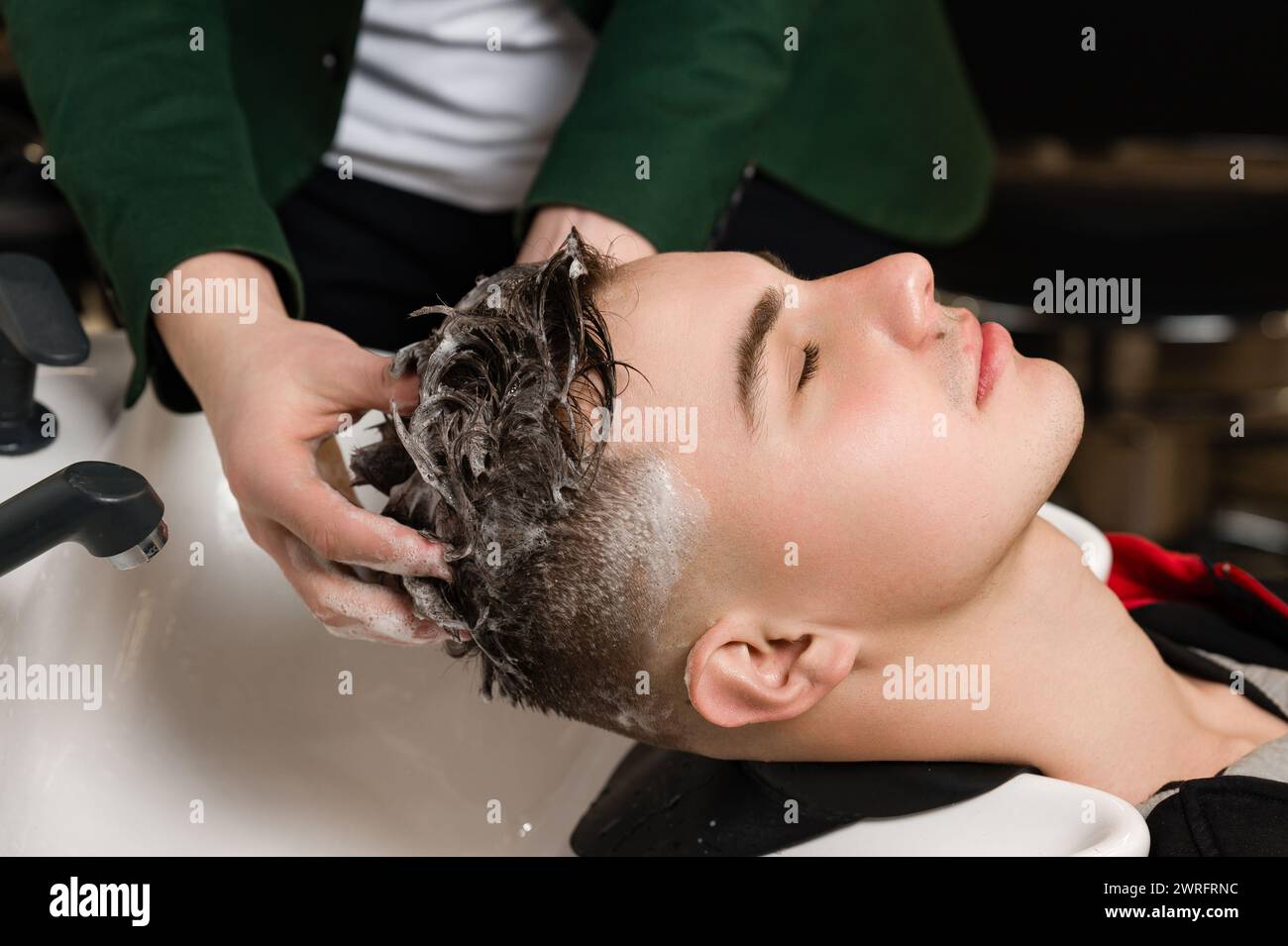 Barber shampooing washing a male client's head in the sink Stock Photo ...